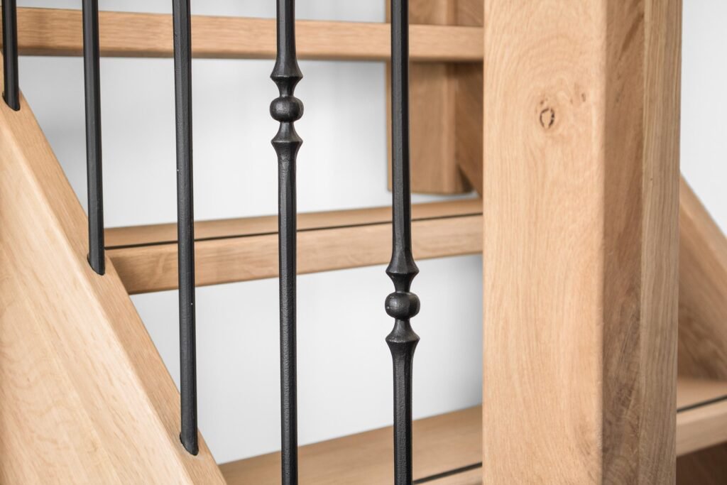 eiken open trap met smeedijzeren spijlen